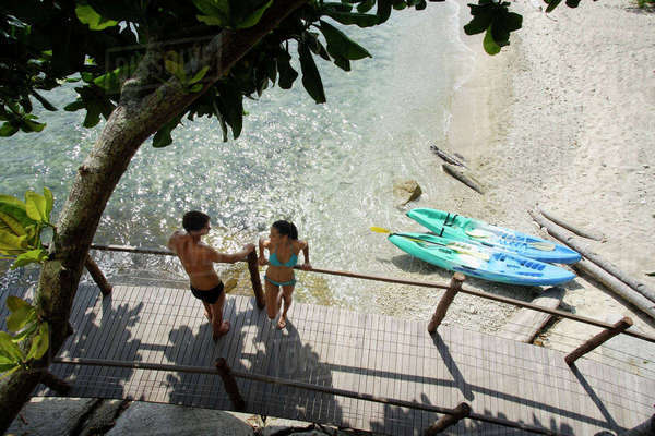 Couple on bridge over beach - Royalty-free Stock Photo | Dissolve