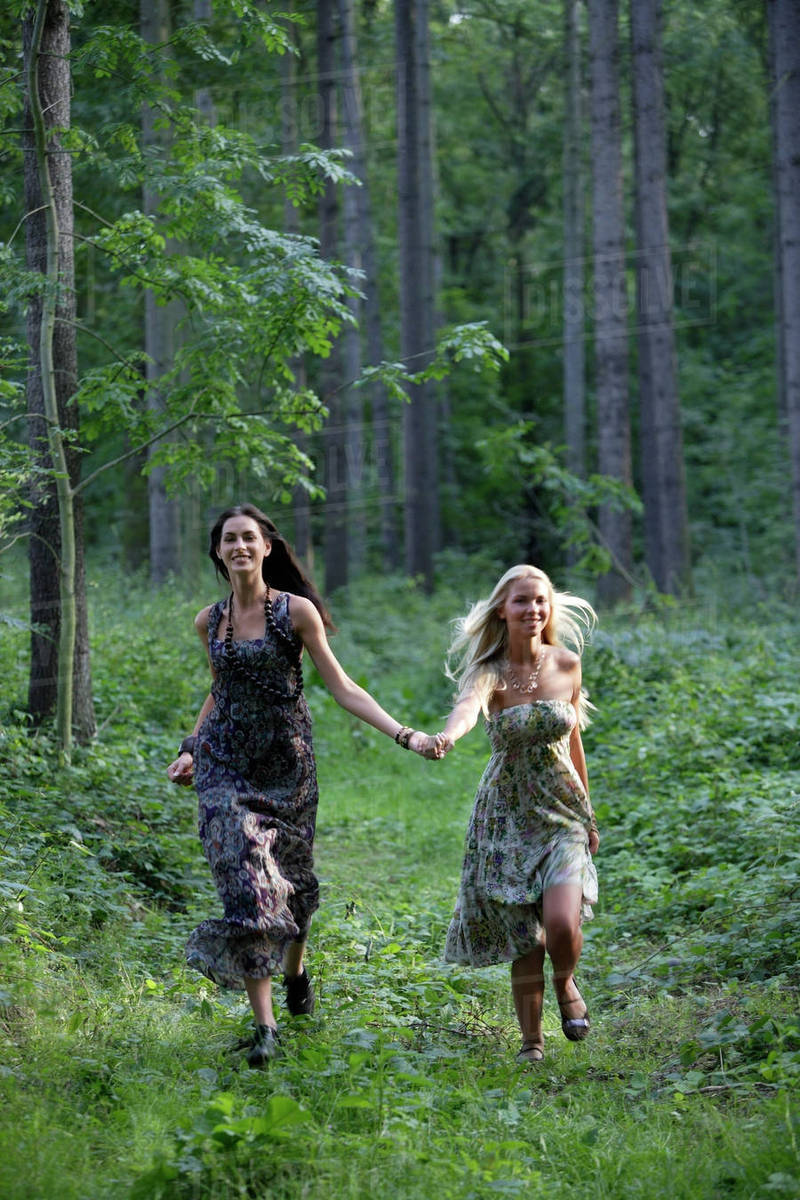 Young women running through forest - Royalty-free Stock Photo | Dissolve