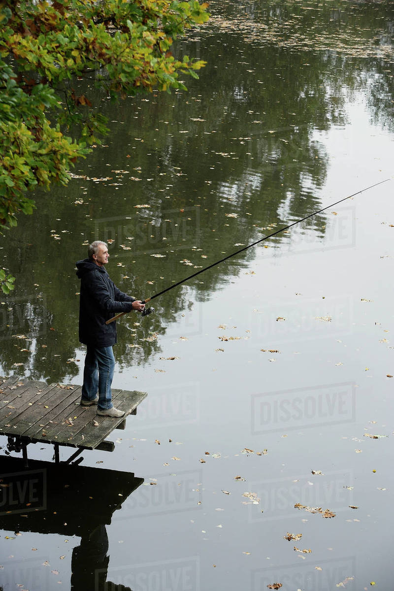 Senior man fishing off pier - Royalty-free Stock Photo | Dissolve