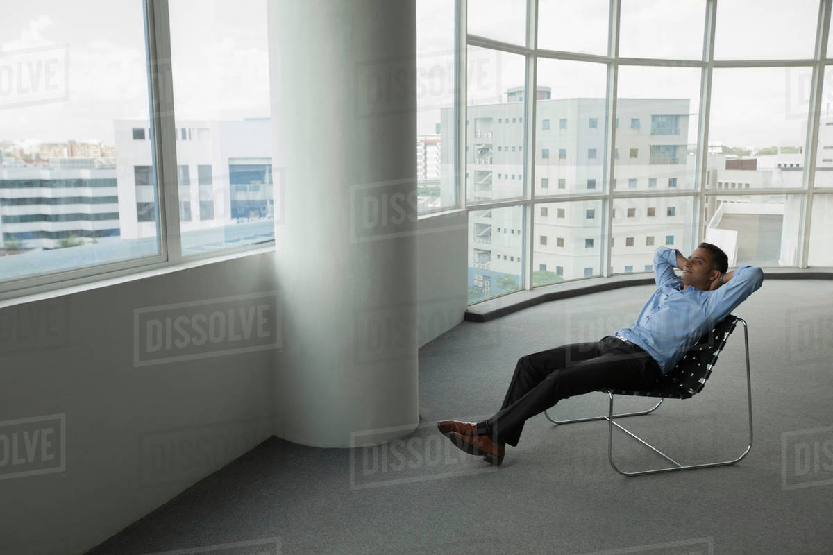 Businessman sitting in chair in empty office - Royalty-free Stock Photo ...