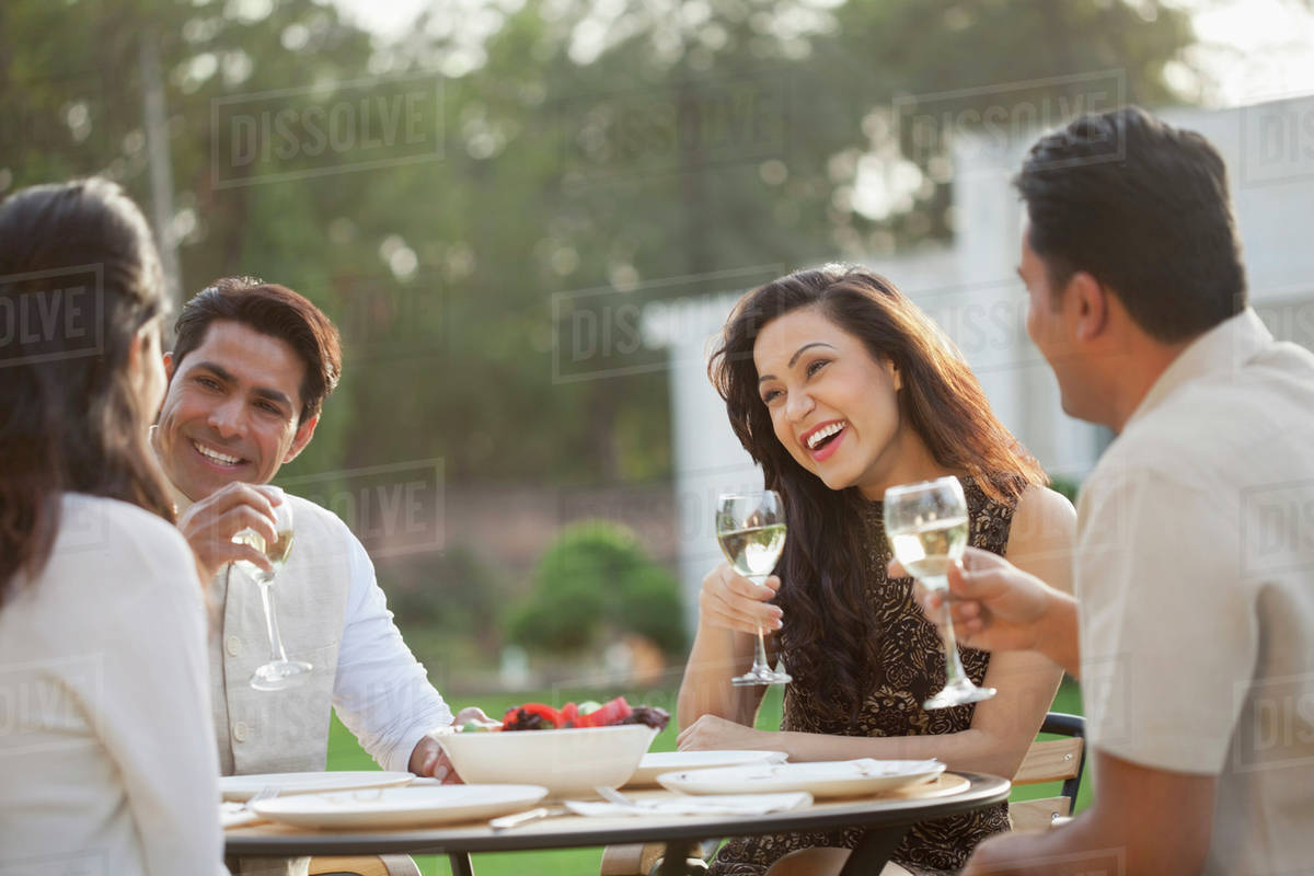Friends drinking wine at table on backyard - Royalty-free Stock Photo ...