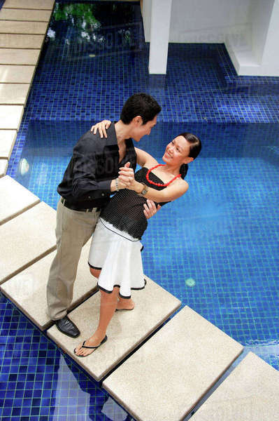 Couple dancing by swimming pool, man dipping woman - Royalty-free Stock ...