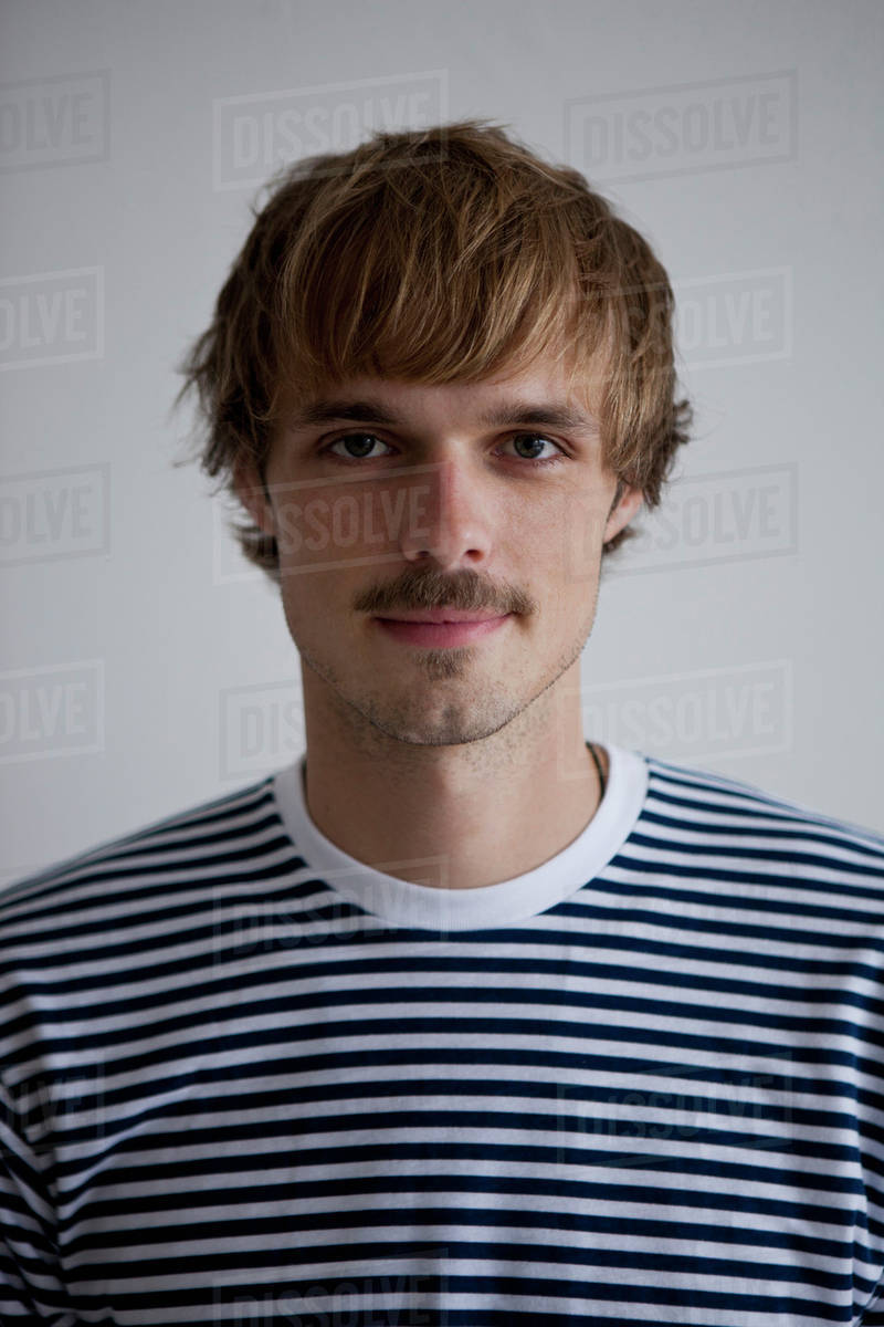A Hip Young Man Wearing A Striped T Shirt Looking At Camera Stock