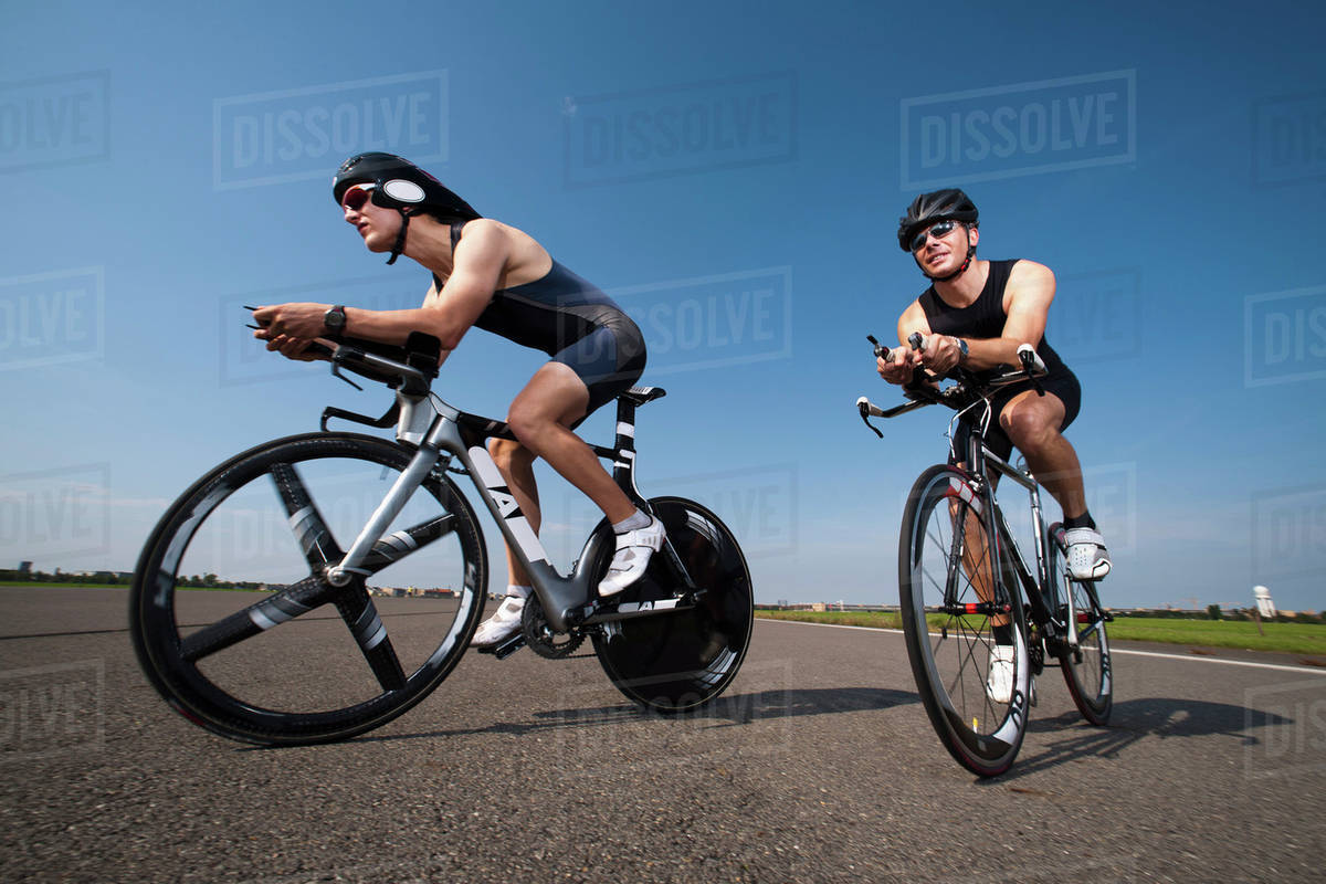 Two cyclists on racing bicycles, side view, low angle view - Royalty ...