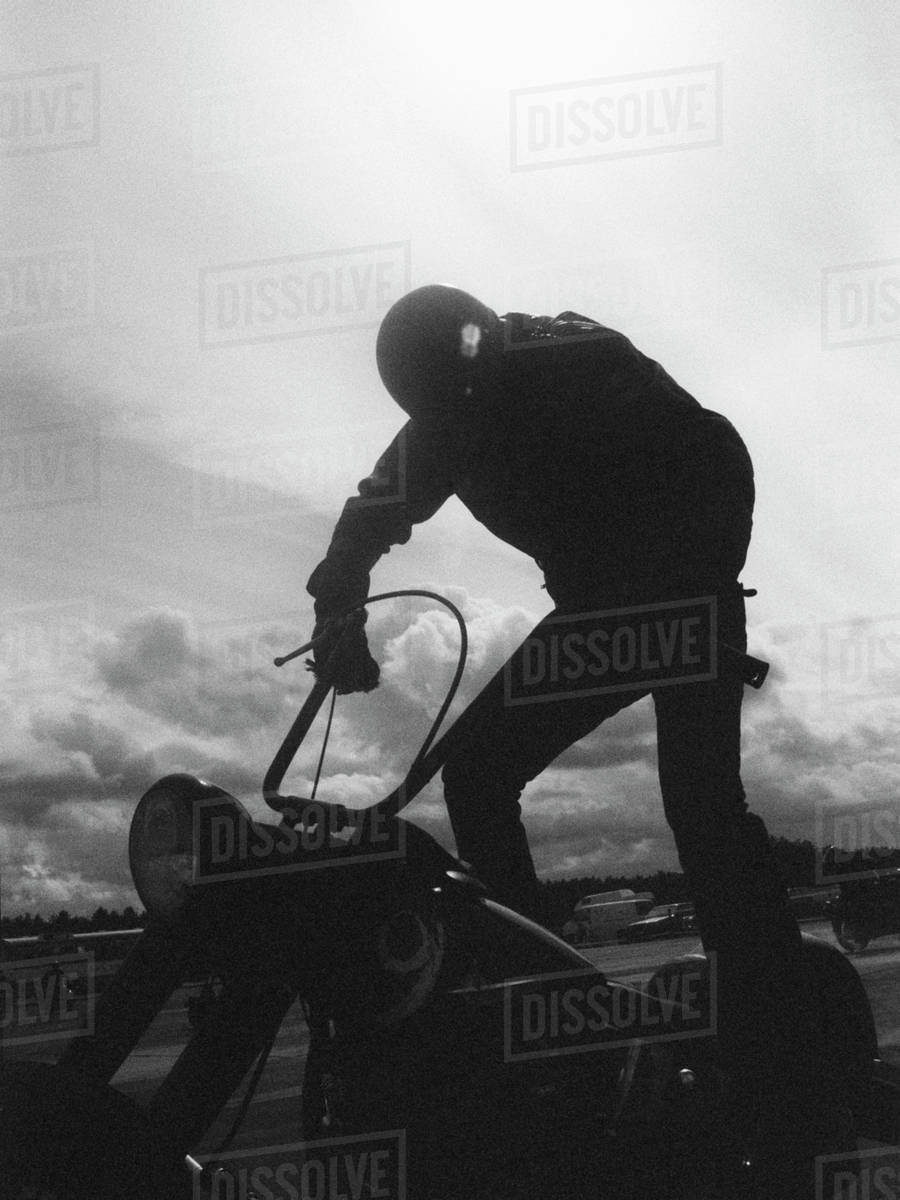 A man standing on a motorcycle - Royalty-free Stock Photo | Dissolve
