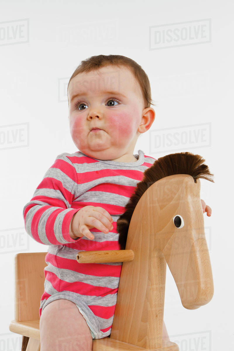 A baby girl on a rocking horse - Royalty-free Stock Photo | Dissolve