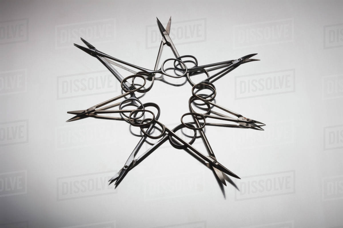 A group of surgical scissors arranged in a star shaped pattern ...