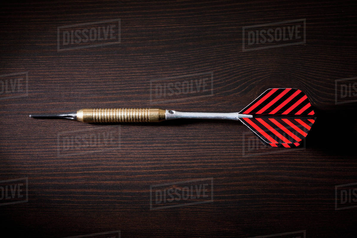 A single dart lying on its side - Stock Photo - Dissolve