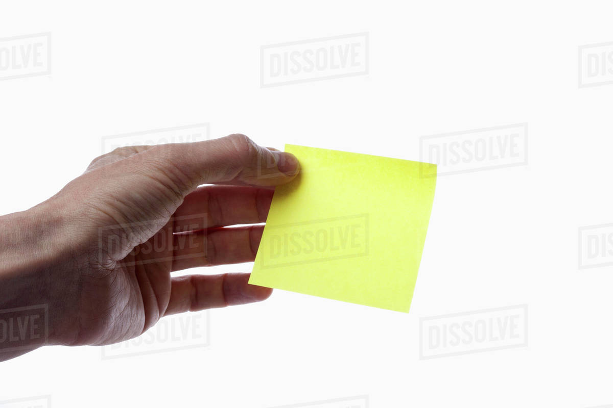 A man holding a blank yellow adhesive note, close-up of hand - Royalty ...