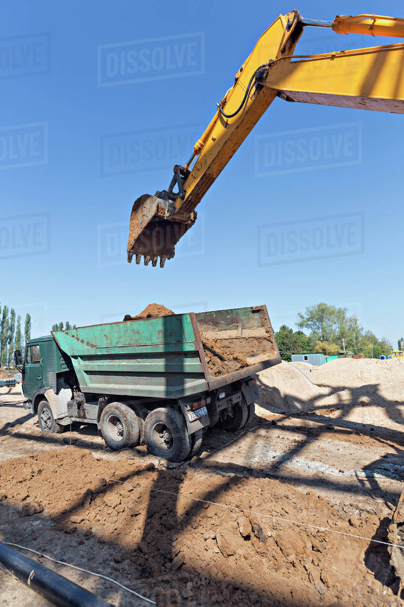 Digger loading soil onto dumper truck - Royalty-free Stock Photo | Dissolve
