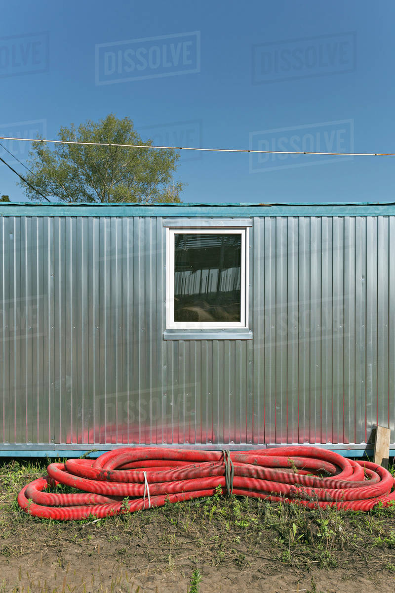 Red conduit tied up in front of industrial building - Royalty-free ...