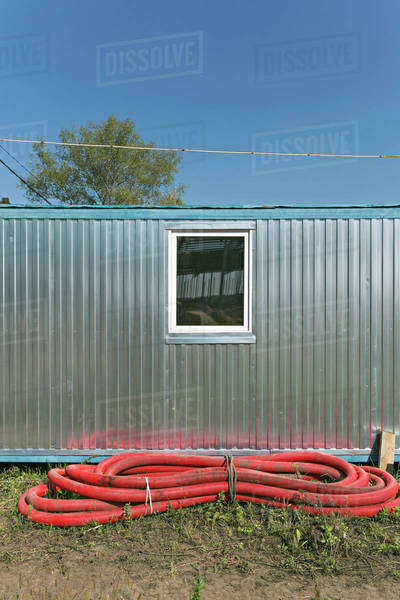 Red conduit tied up in front of industrial building - Royalty-free ...