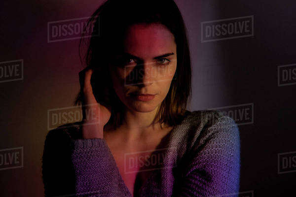 A woman looking suggestively into the camera while touching her hair ...