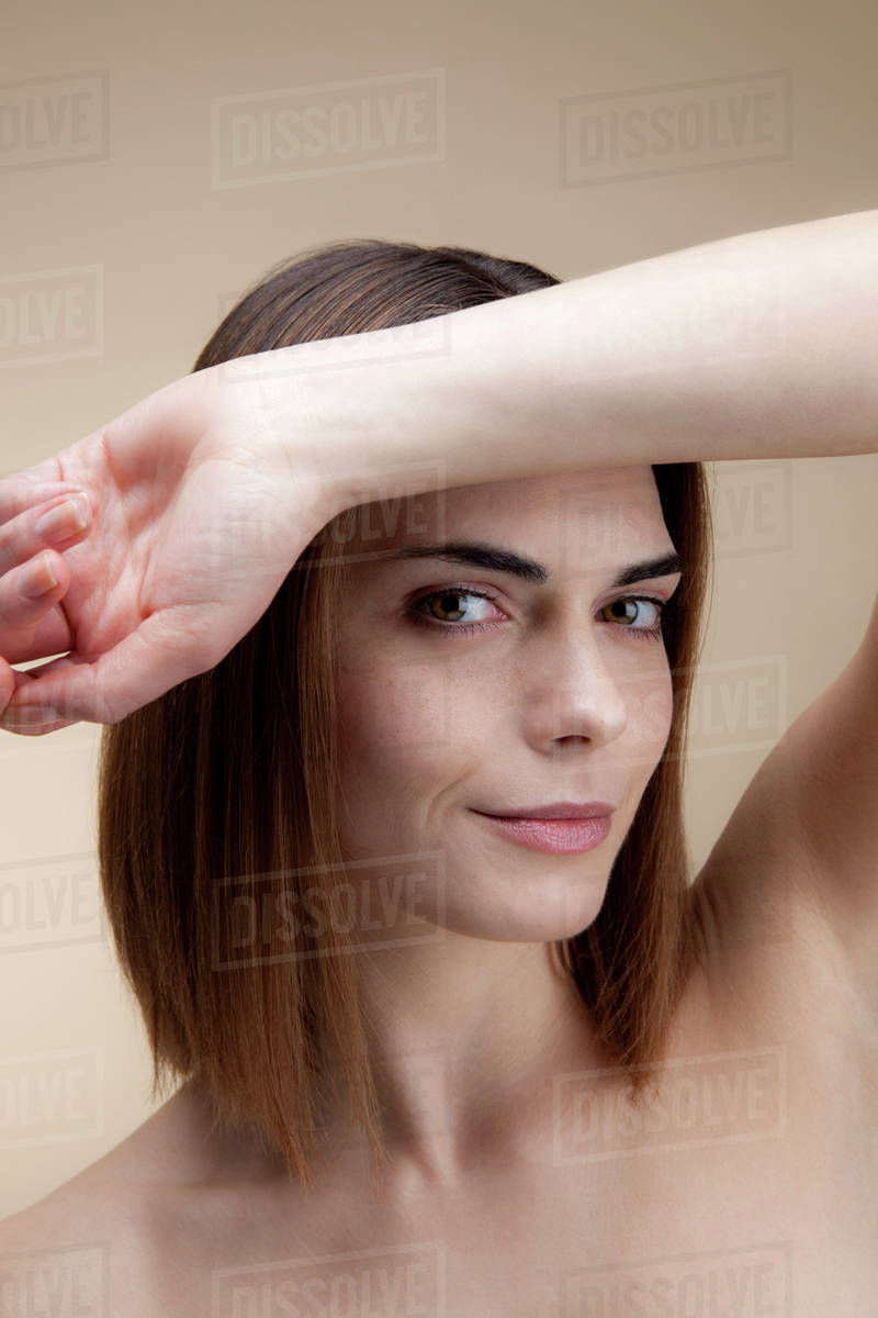 A beautiful young woman with her forearm resting on her forehead ...