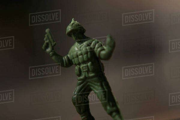 A toy solider holding a gun with arms raised up in surrender - Stock ...