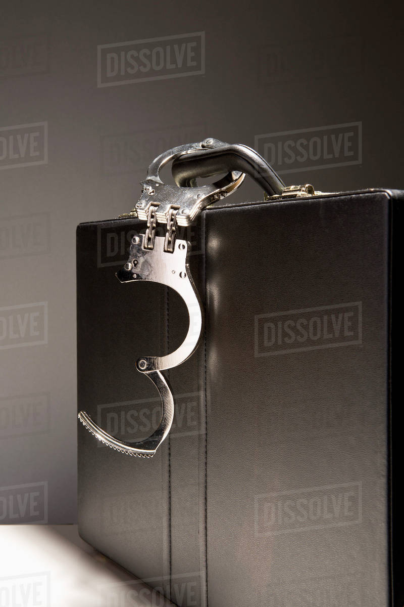 A briefcase with handcuffs attached to the handle - Royalty-free Stock ...