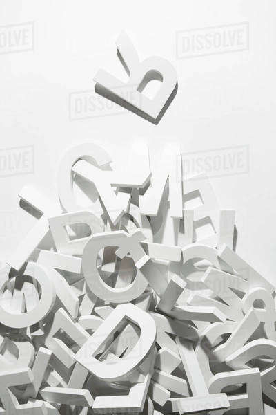 A heap of white block letters with the letter R placed above the pile ...