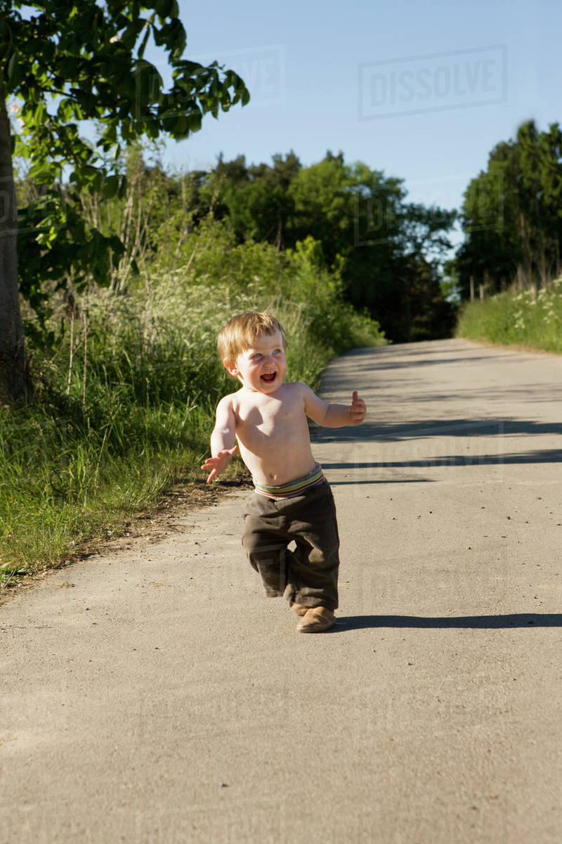 Baby girl running on single track - Stock Photo - Dissolve