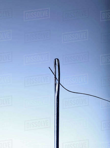 A needle being threaded, close-up - Royalty-free Stock Photo | Dissolve