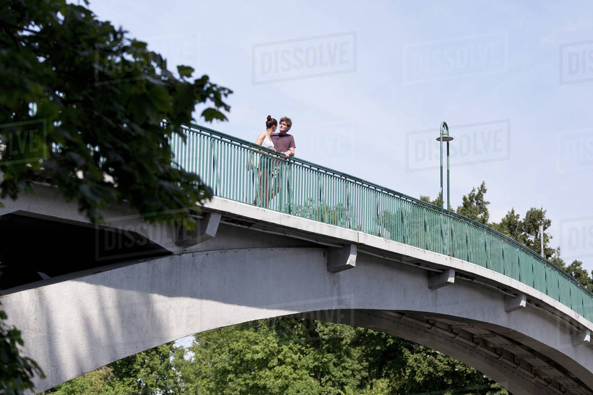 Young couple standing on bridge - Royalty-free Stock Photo | Dissolve