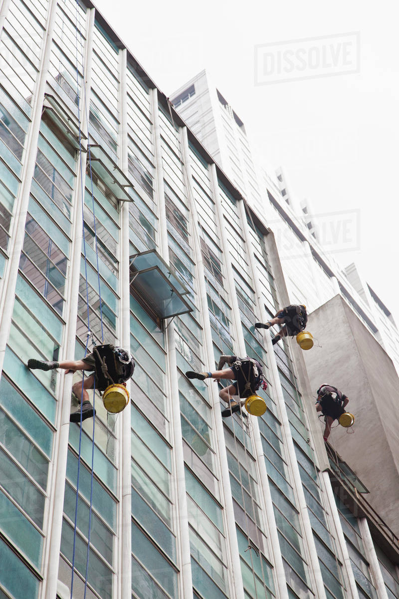 Workers cleaning the glass windows of skyscraper - Stock Photo - Dissolve