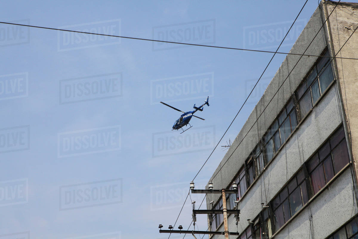 Low angle view of helicopter flying over building - Royalty-free Stock ...