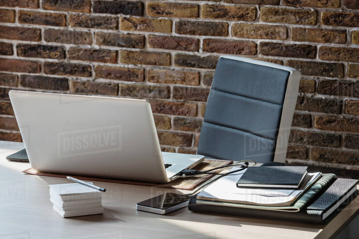 Laptop on desk in office - Royalty-free Stock Photo | Dissolve