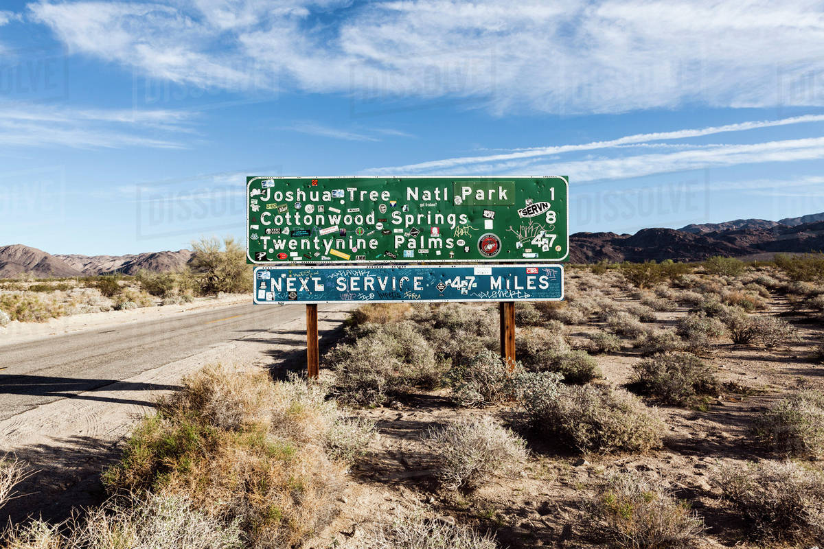 Information sign by road at Joshua Tree National Park against sky ...