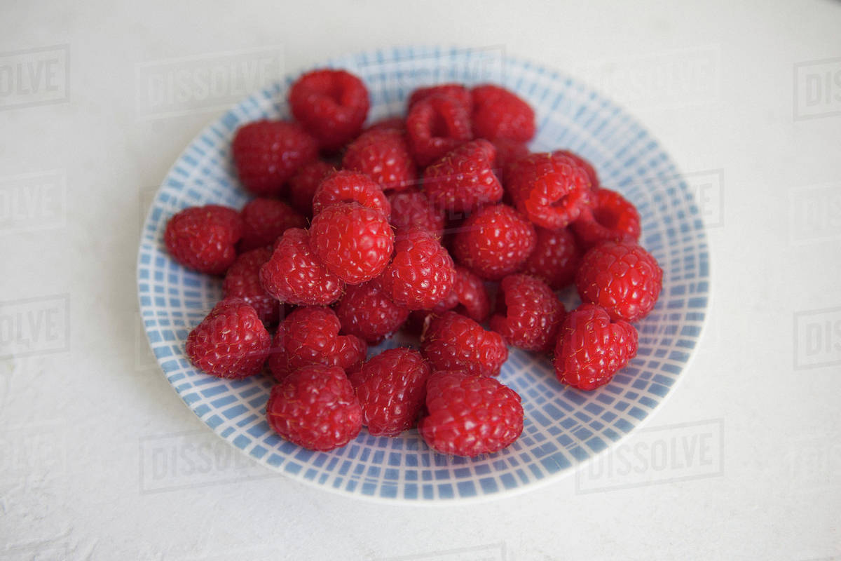 Raspberries in plate on white background - Stock Photo - Dissolve