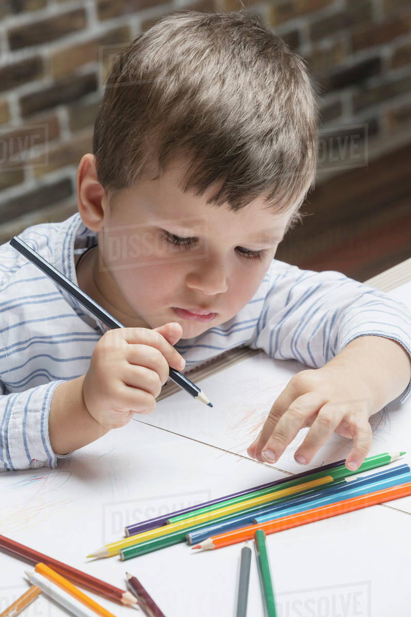 Boy coloring on paper at table in house - Royalty-free Stock Photo ...