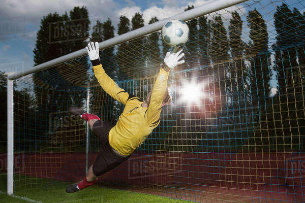 Full length of soccer goalkeeper diving to block ball - Stock Photo ...
