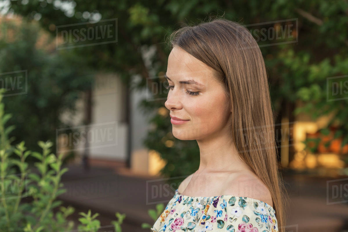 Side view of beautiful young woman outdoors - Stock Photo - Dissolve