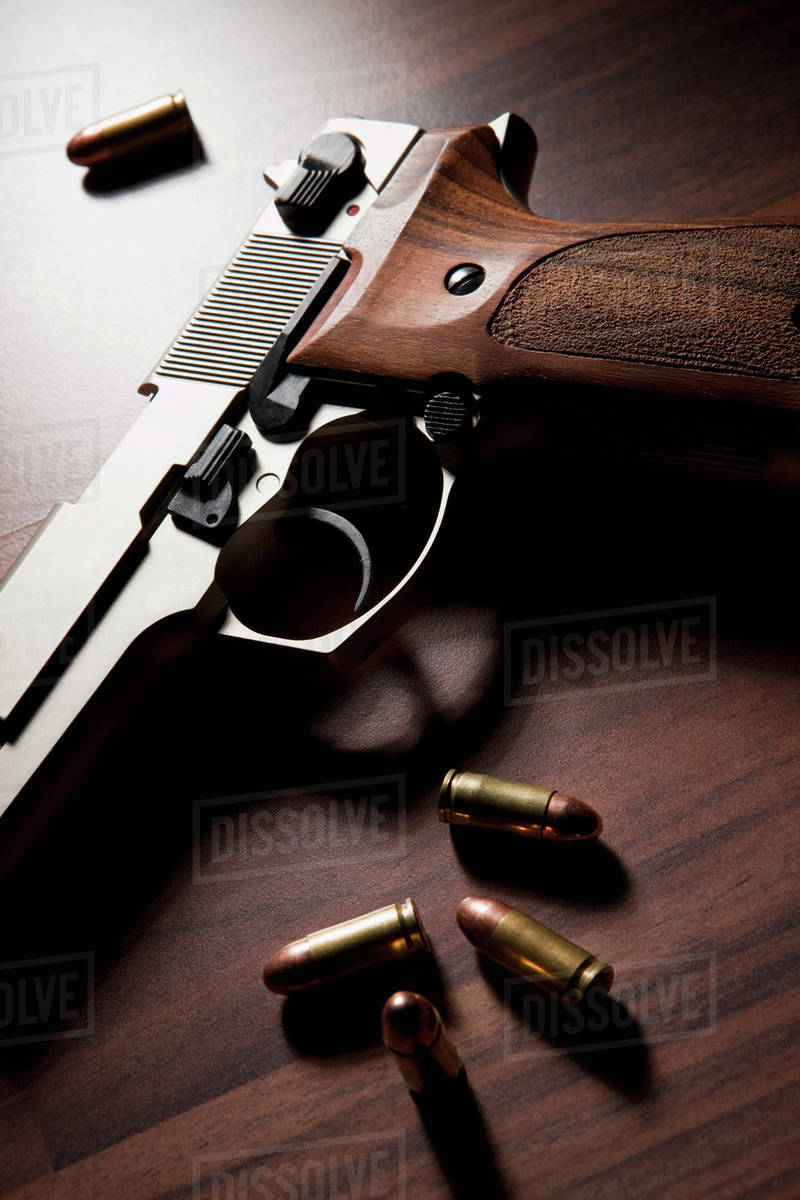 A Handgun With Bullets - Stock Photo - Dissolve