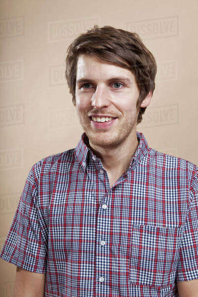 Portrait of a man with a goofy smile, looking away, studio shot ...