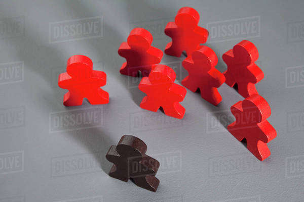 A group of red wooden stick figures confronting a brown wooden stick ...