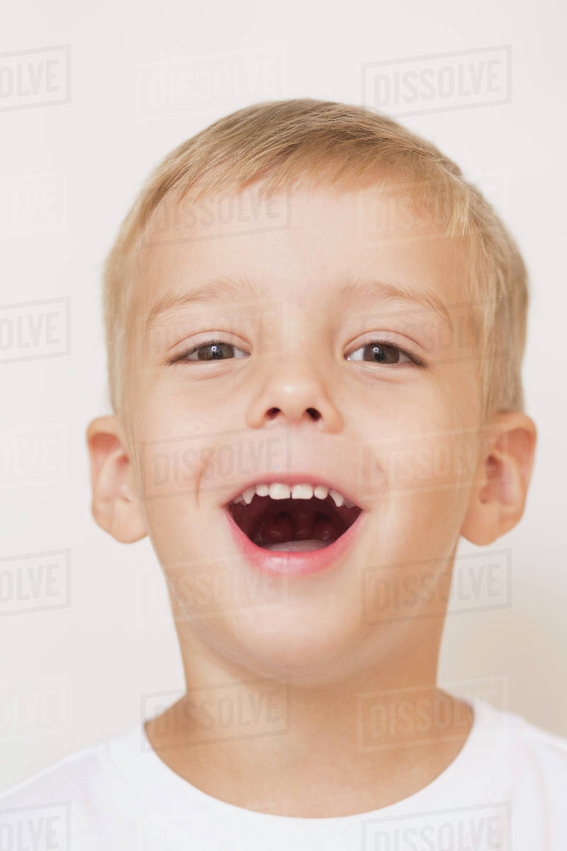 Portrait of happy boy against white background - Stock Photo - Dissolve