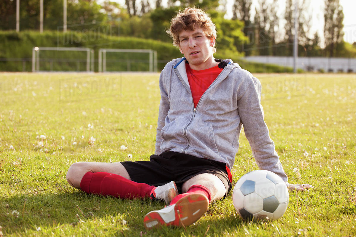 Portrait of young soccer player resting on field - Royalty-free Stock ...