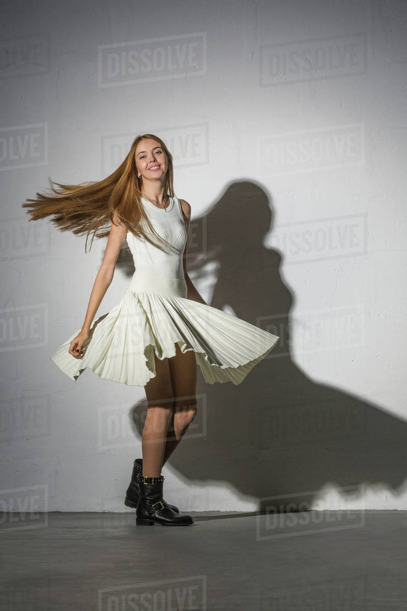 Full length portrait of woman spinning against white background - Stock ...