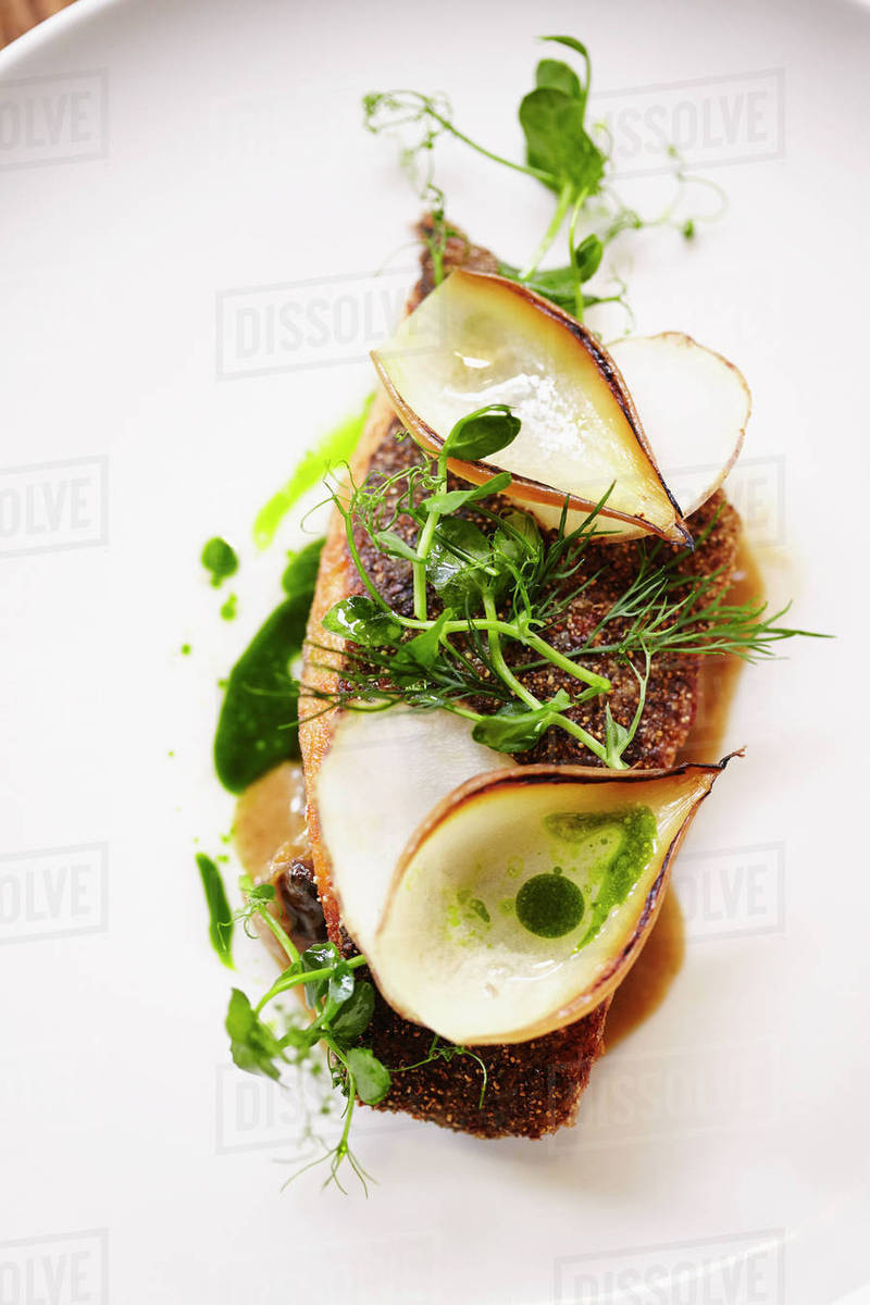 Close-up of fried turbot fillet garnished with herbs on plate - Royalty ...