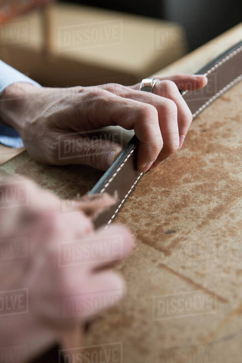 Cropped image of hand holding belt on table - Royalty-free Stock Photo ...