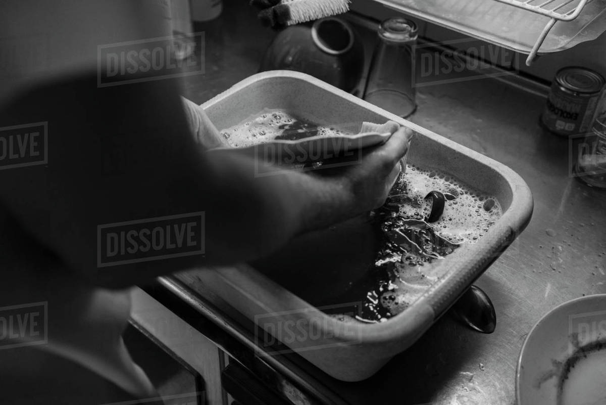 Man washing utensils in trough on kitchen counter - Royalty-free Stock ...