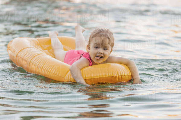 Cheerful cute girl floating on raft in lake - Royalty-free Stock Photo ...