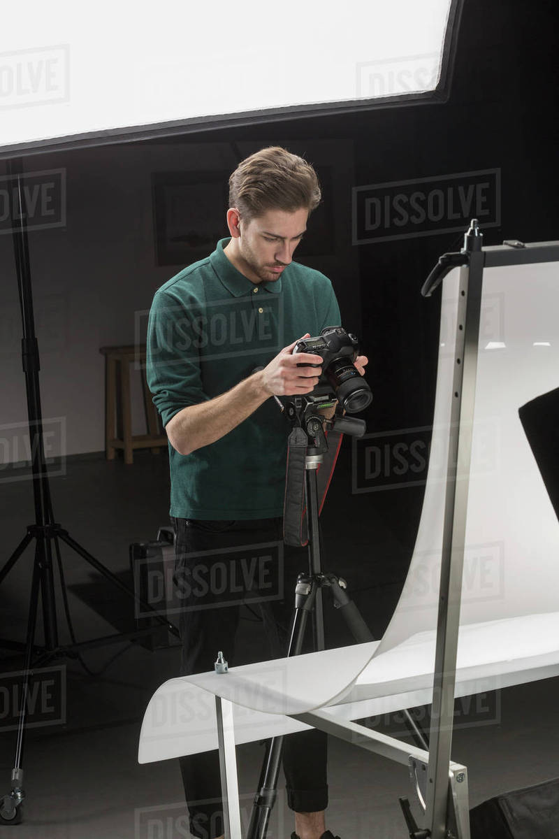 Confident photographer looking at backdrop while working in studio ...