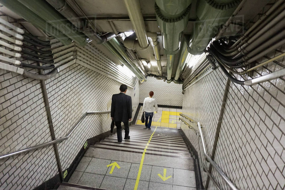 High angle view of people moving down on steps at subway station ...