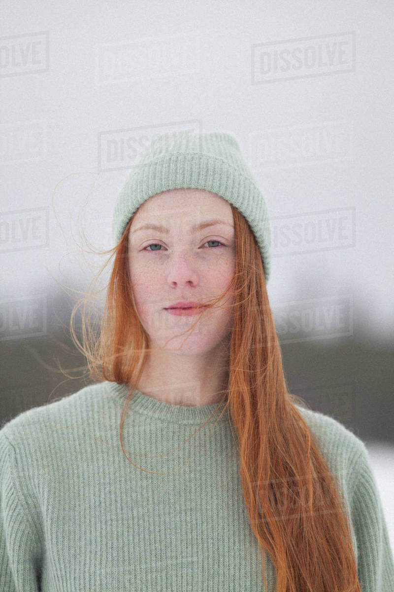 Portrait Of Confident Young Woman With Long Red Hair Wearing Knit Hat