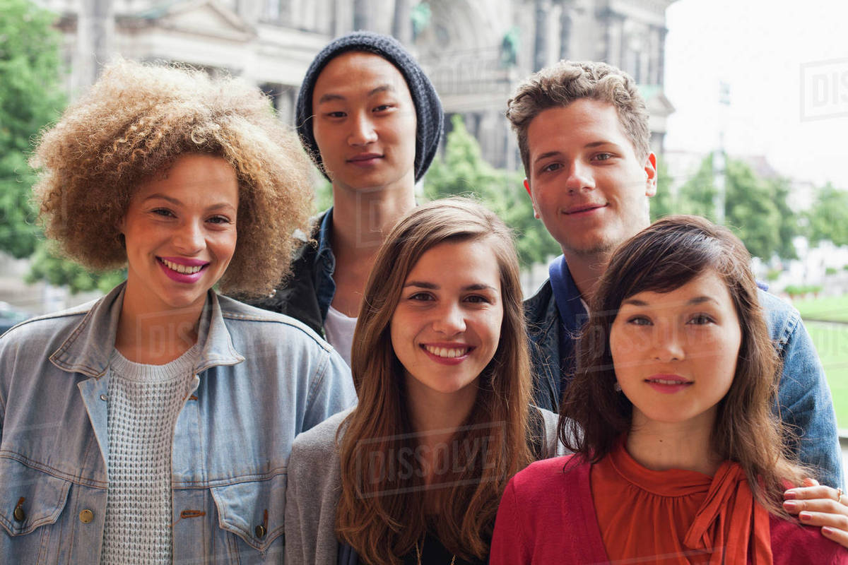 Portrait of smiling multi-ethnic friends standing against Berlin ...