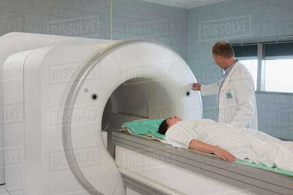 Doctor preparing patient for MRI in hospital - Stock Photo - Dissolve