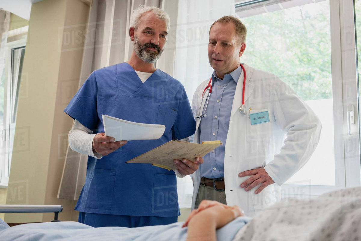 Male doctors making rounds in hospital room - Stock Photo - Dissolve