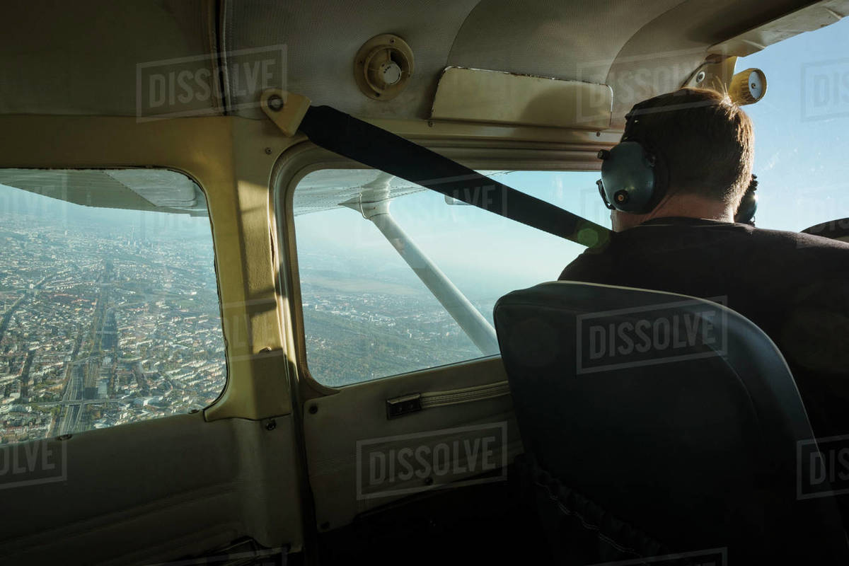 Man flying small airplane over city - Royalty-free Stock Photo | Dissolve