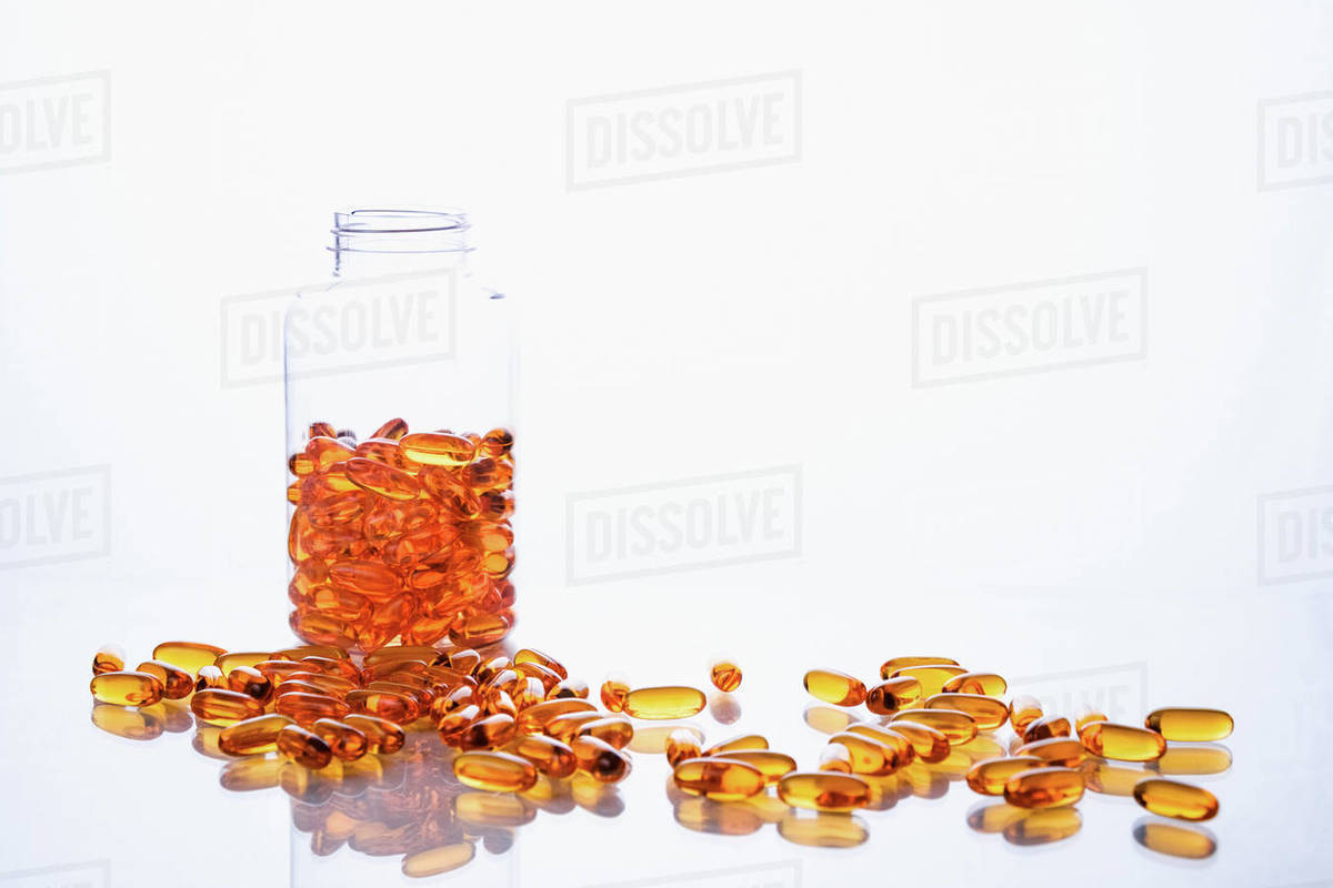Orange medicine capsules and bottle on white background - Stock Photo ...